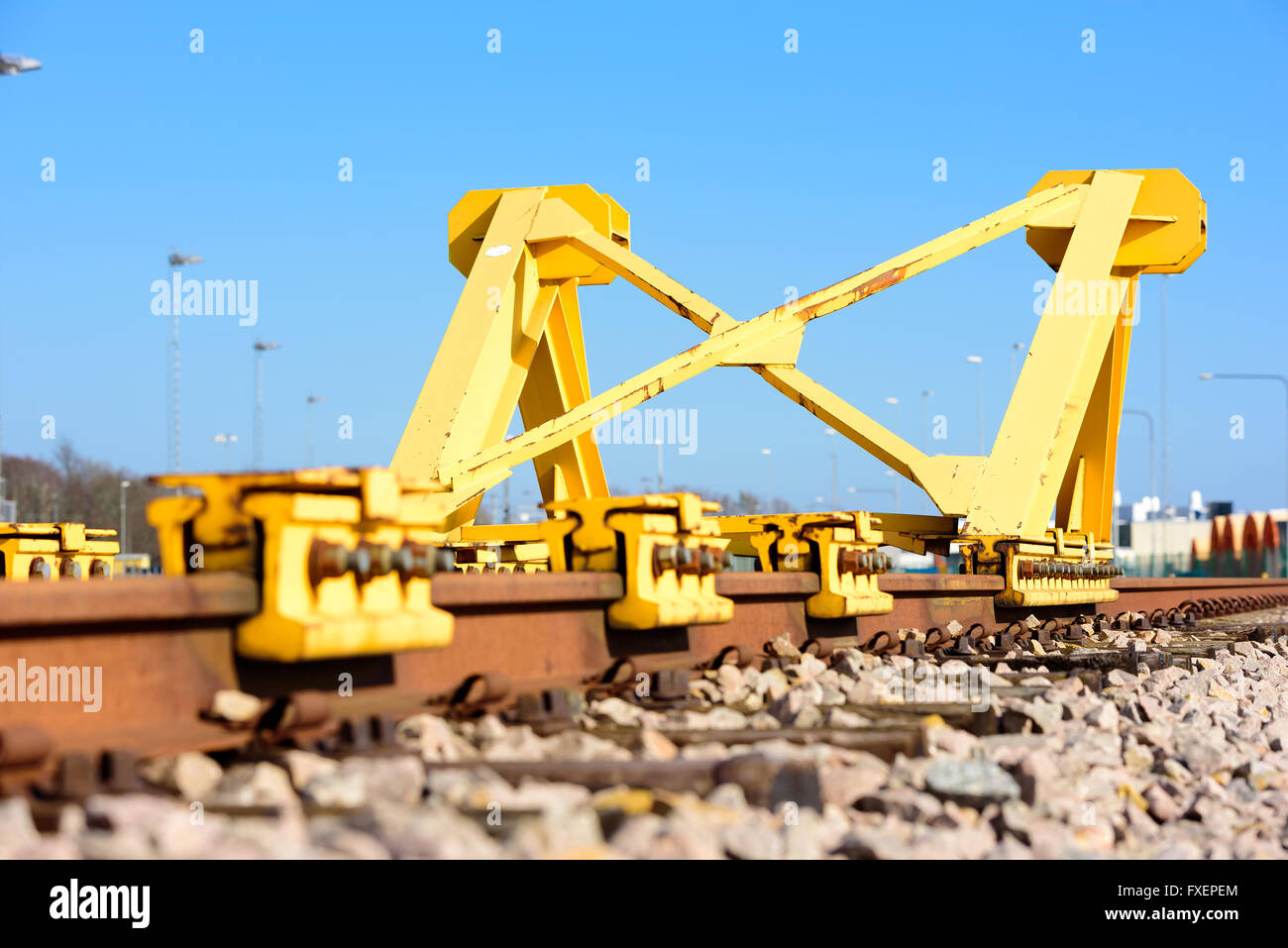 Bright yellow train buffer stop or bumper at the end of a railway track ...