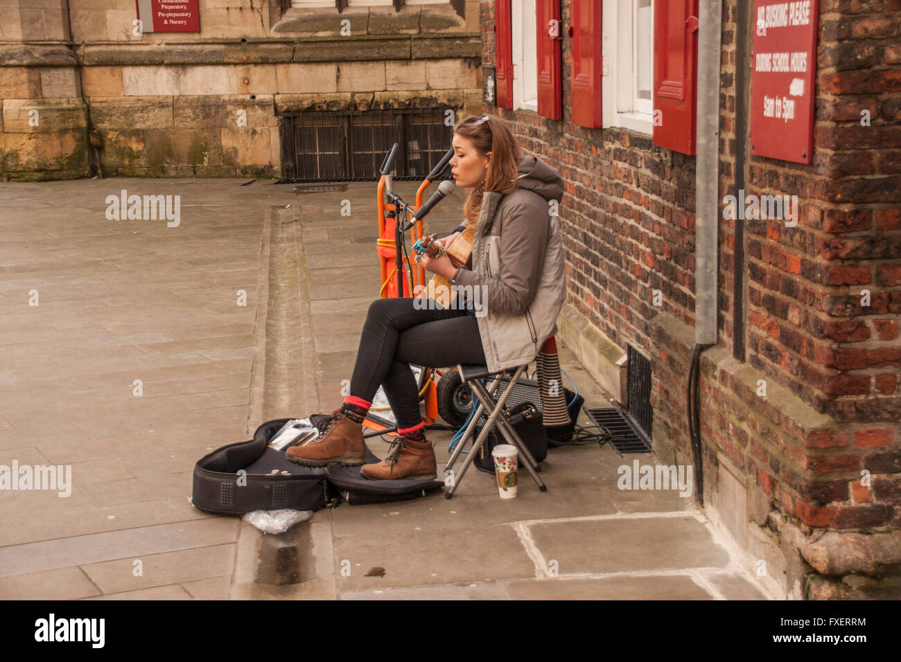 A young female singer busking in the city center of York,North ...