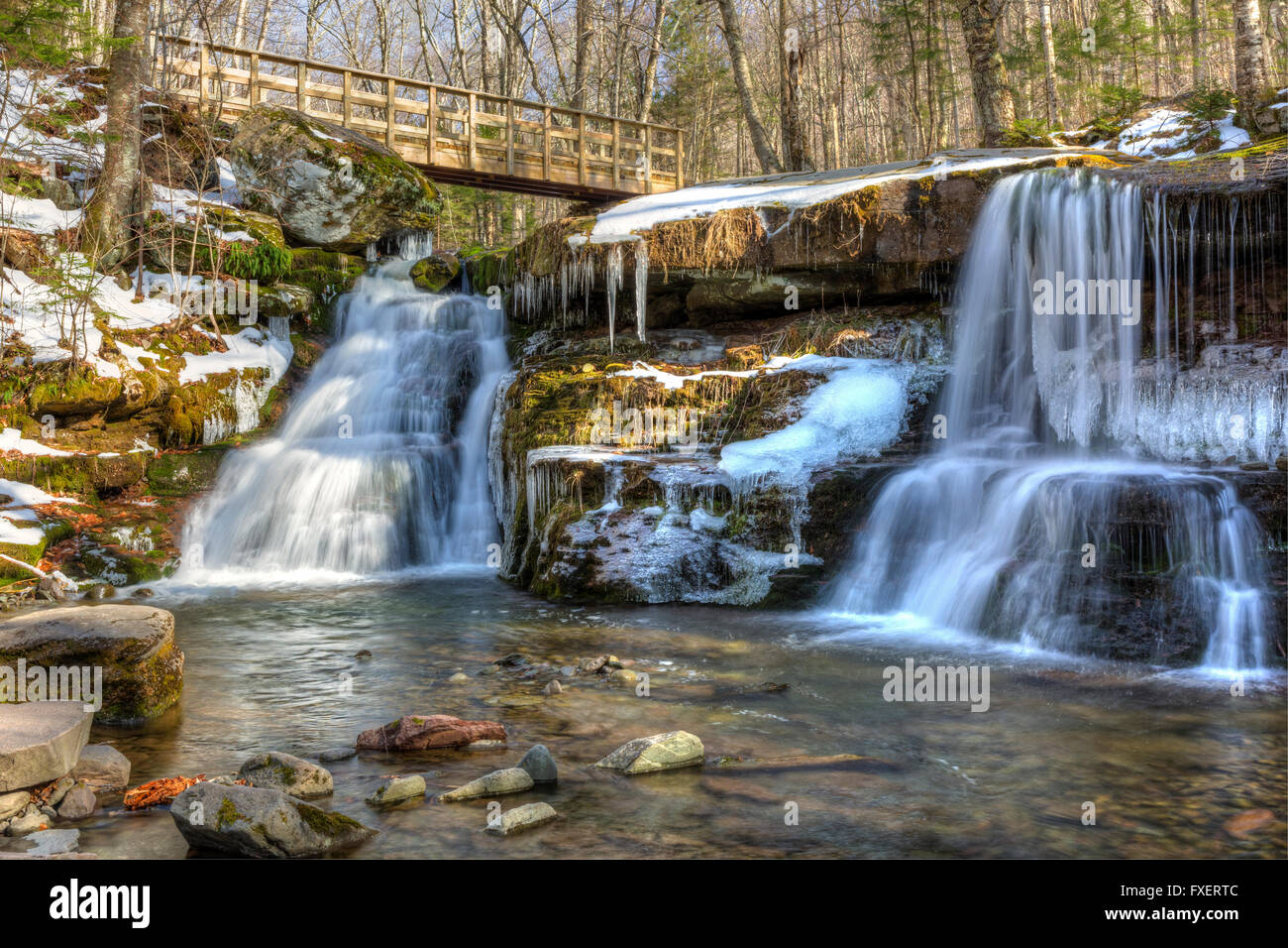 Water falls gently over rocky strata at partially frozen West Kill ...
