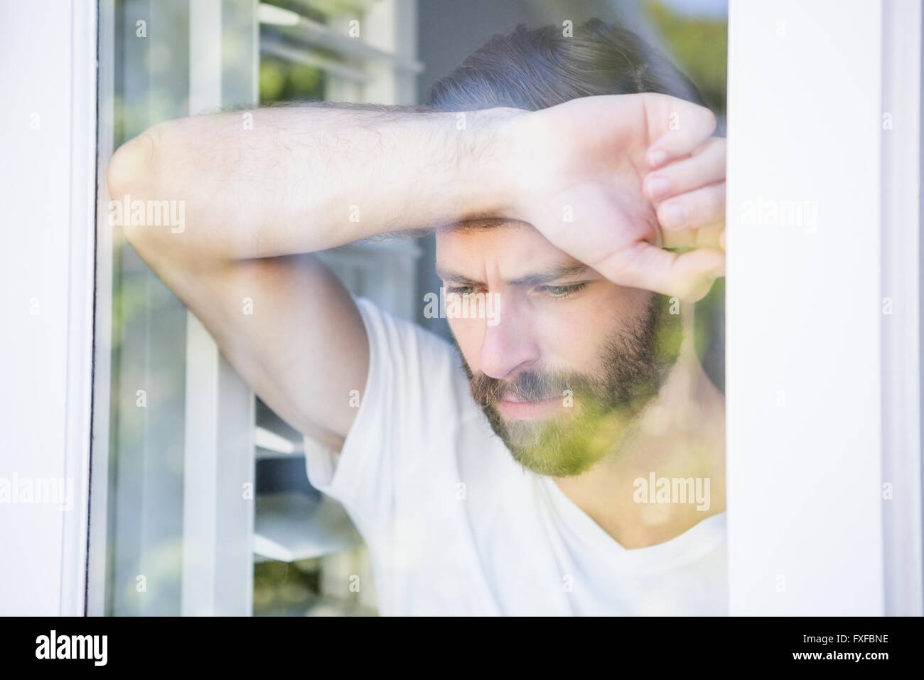 Depressed man leaning his head on window glass Stock Photo - Alamy