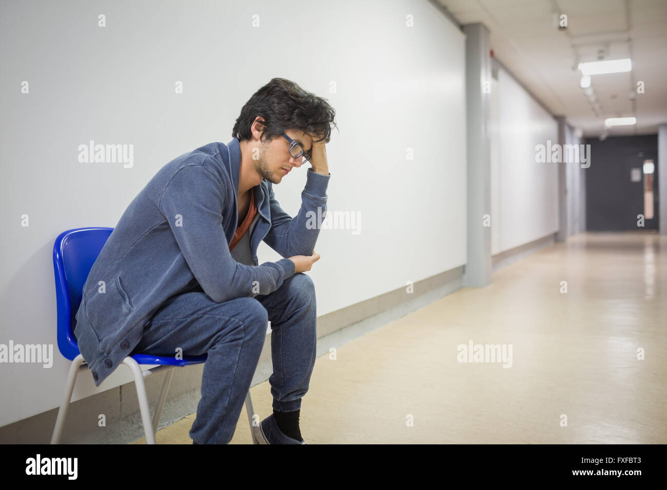 Thoughtful student sitting on chair Stock Photo - Alamy