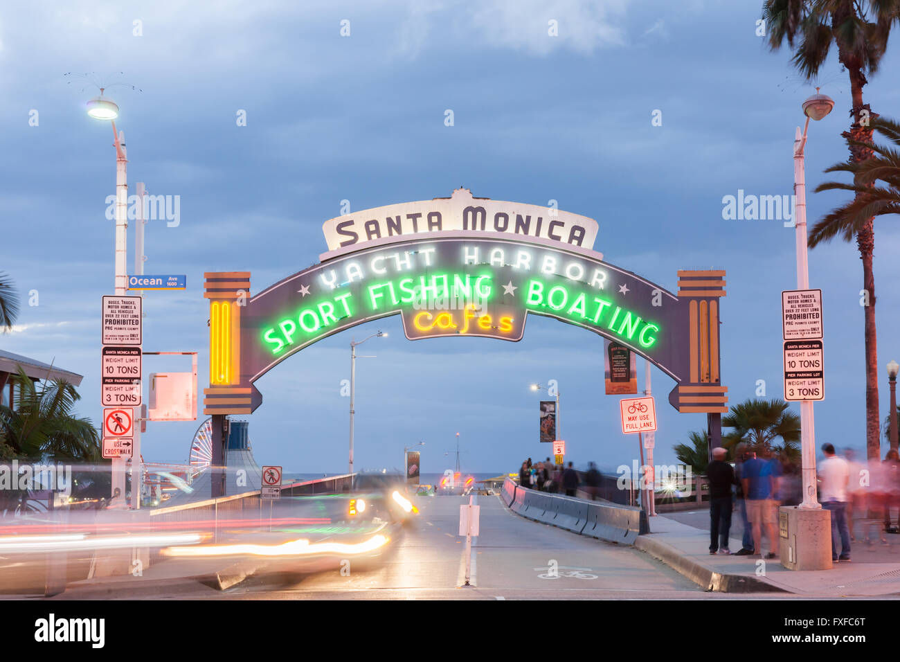 Neon entrance sign and arch to Route 66 Santa Monica Pier at night long ...