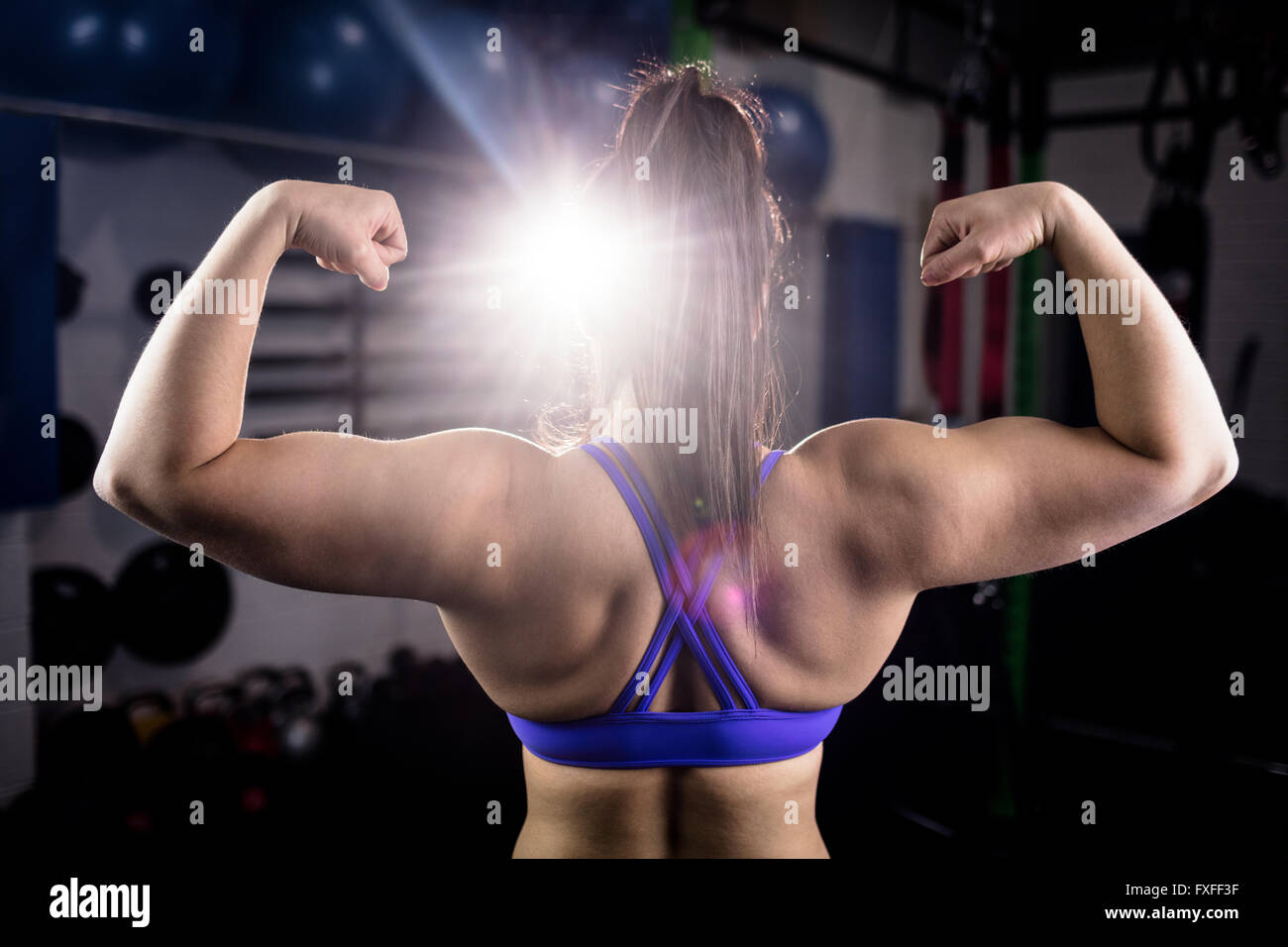 Rear view of woman flexing muscles Stock Photo - Alamy