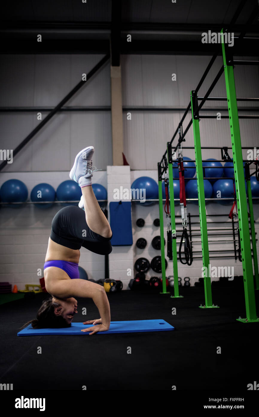 Side view of a woman performing a headstand on mat Stock Photo - Alamy