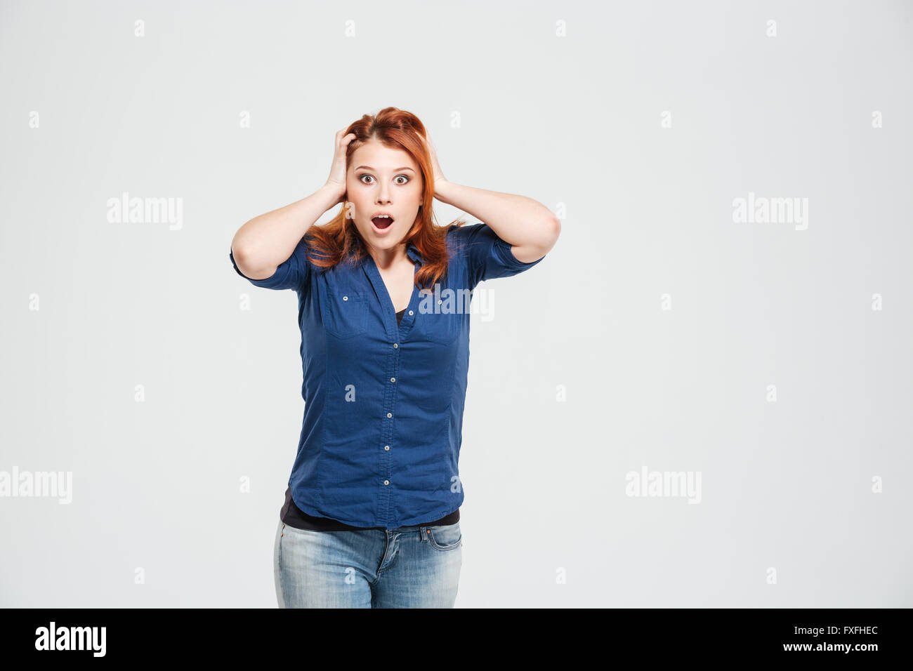 Shocked stunned redhead young woman with opened mouth standing with ...