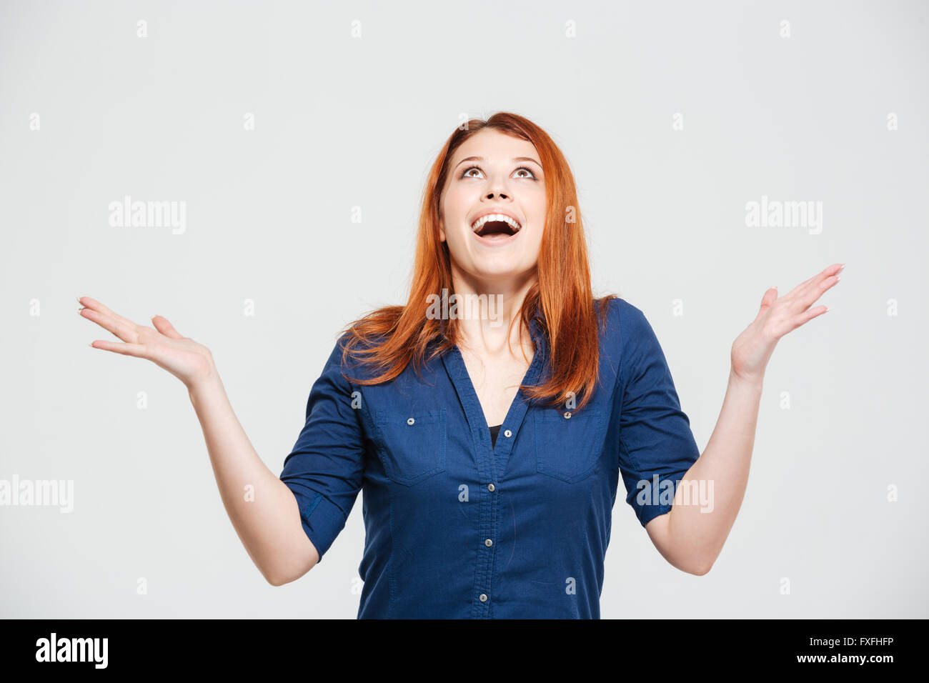 Excited happy redhead young woman trying to catch something falling ...