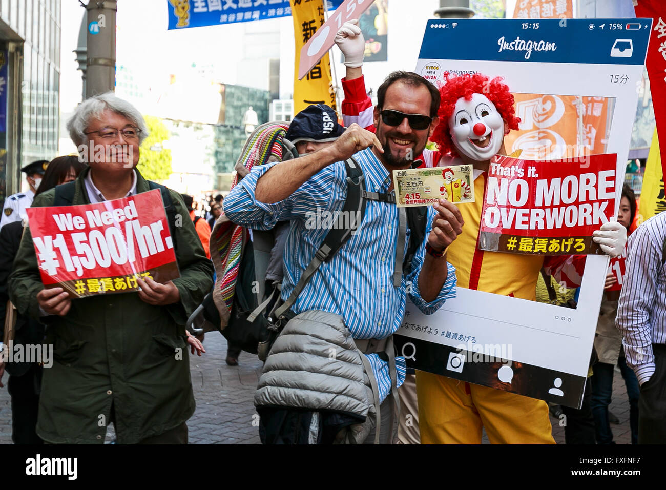 Tokyo, Japan. 15th April, 2016. Fast-food workers hold placards ...
