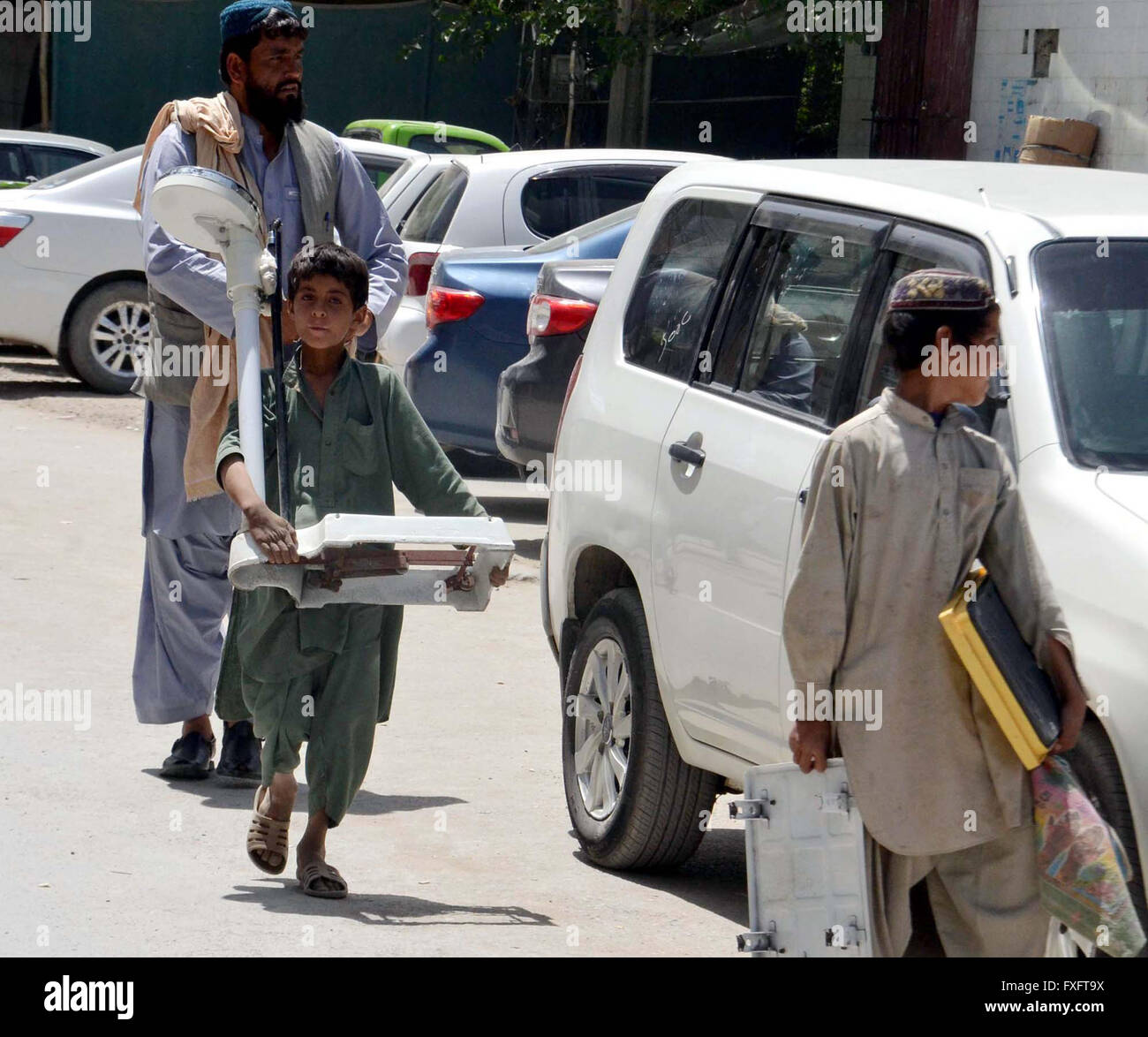 A hawker child weighs people to earn his livelihood for support of his ...