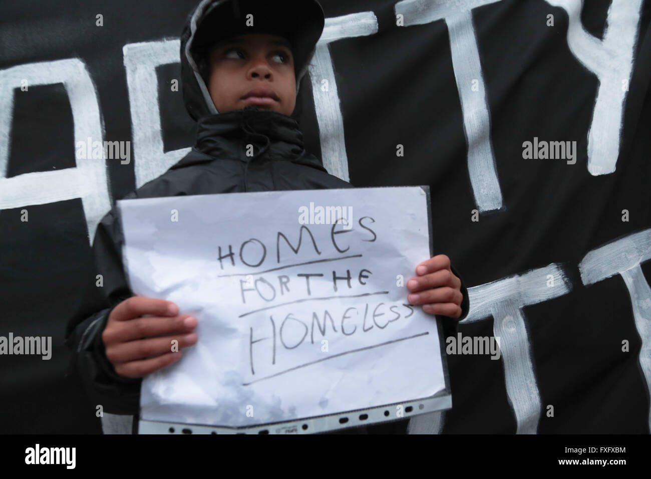 London, UK. 15th Apr, 2016. A boy holds a banner in solidarity with ...