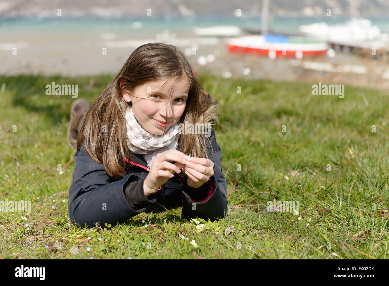 a pretty preteen is lying in the green grass, in the spring Stock Photo ...