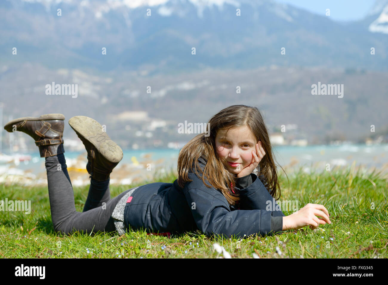 a pretty preteen is lying in the green grass, in the spring Stock Photo ...