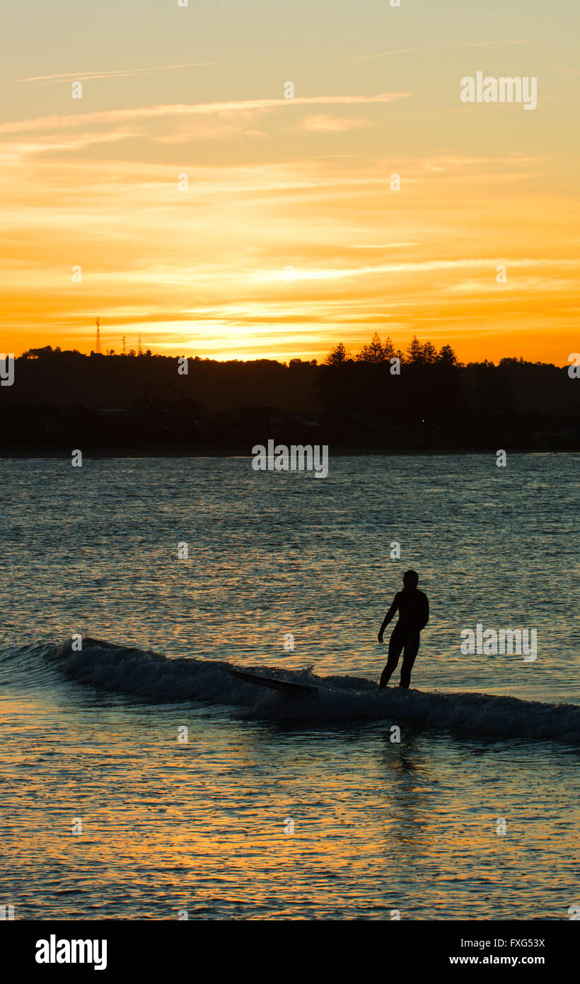 Surfer rides a small wave at The Pass at sunset Stock Photo - Alamy