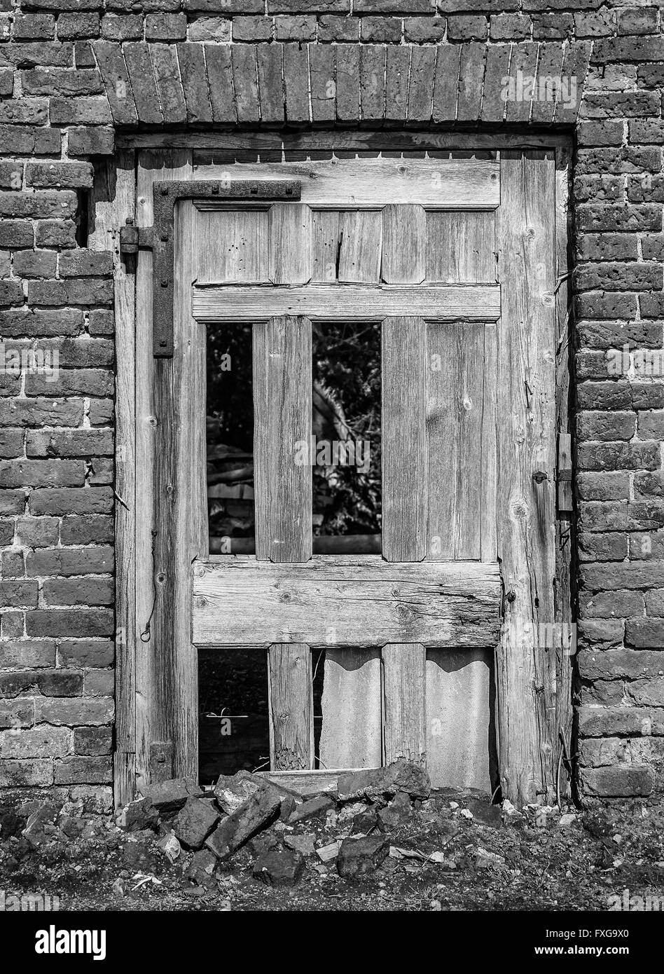 Broken door with missing panels, rusty hinge, old brickwork Stock Photo ...