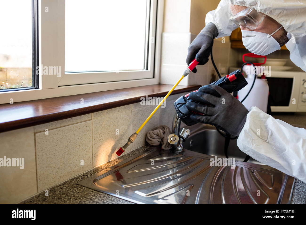 Pest control man spraying pesticide Stock Photo - Alamy