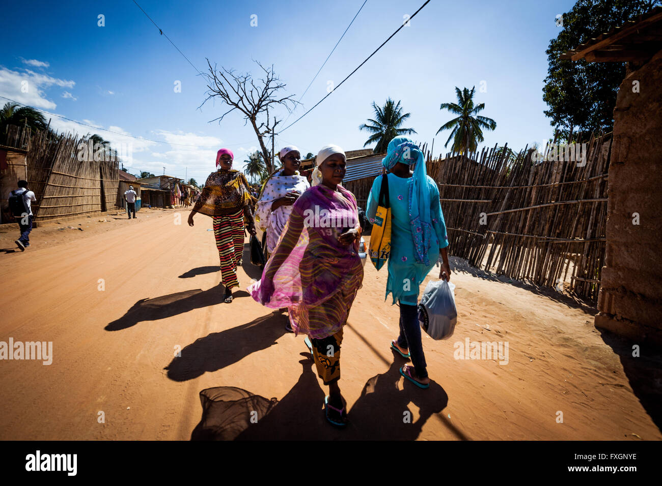 Mozambique, women walking in the street in traditional colored clothes ...