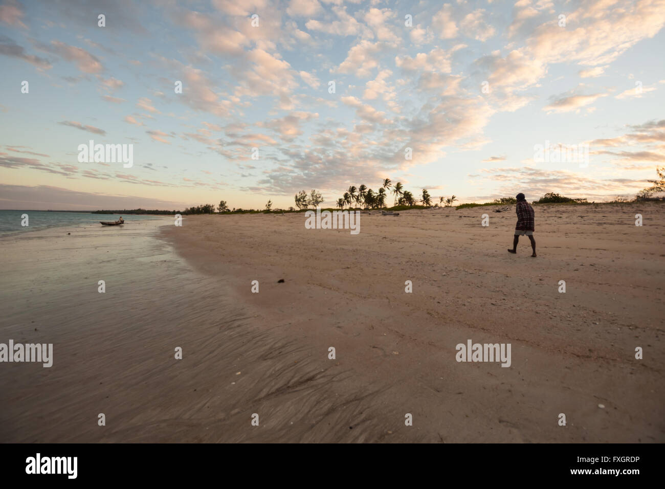 Mozambique, a man is walking on the beach at sunset time Stock Photo ...