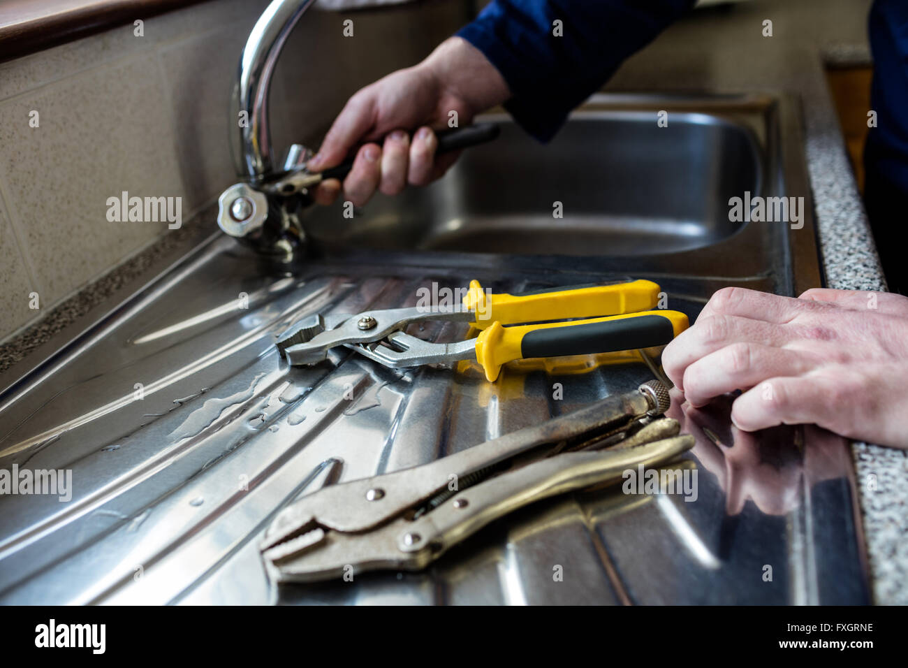 Mans hand fixing the sink with wrench Stock Photo - Alamy