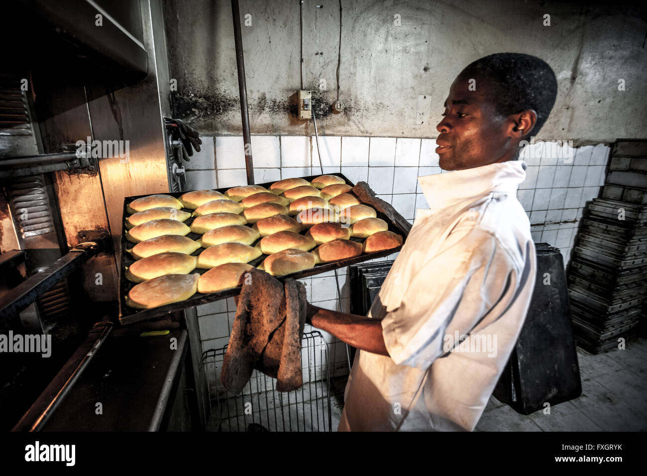 Mozambique, man is baking bread in bakery traditional cousin Stock ...