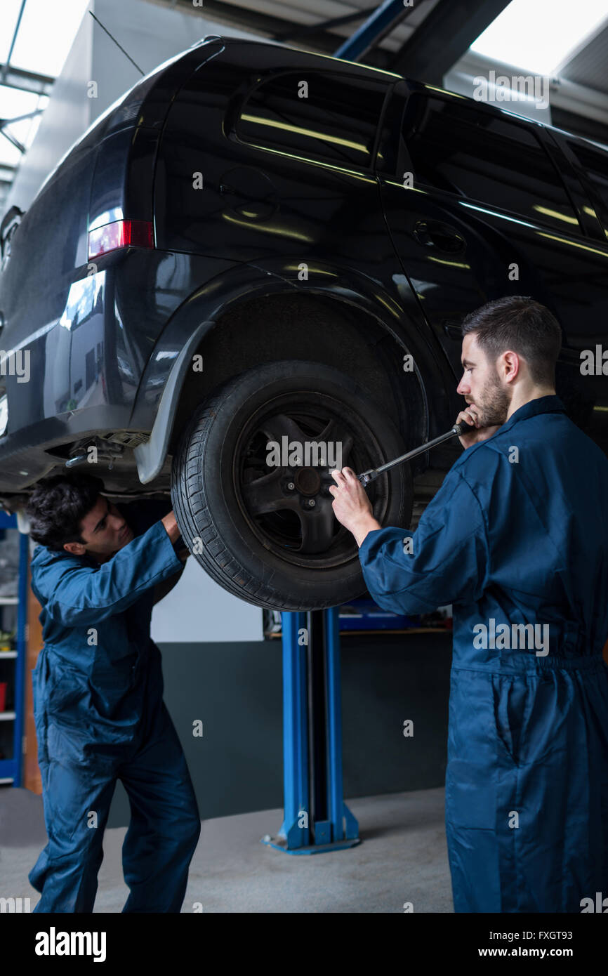 Mechanics changing car wheel Stock Photo - Alamy