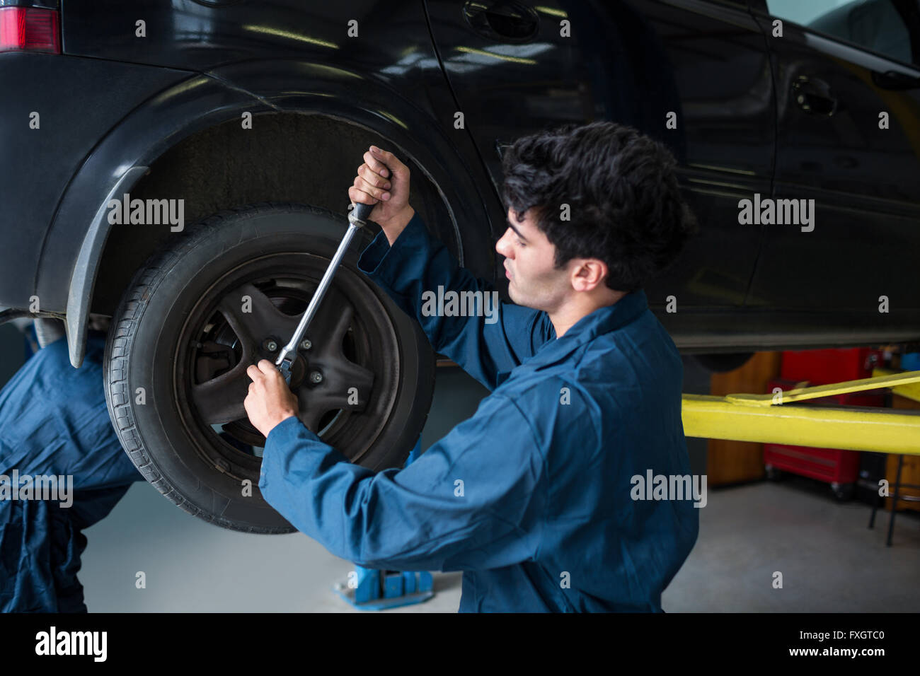 Mechanic changing car wheel Stock Photo - Alamy