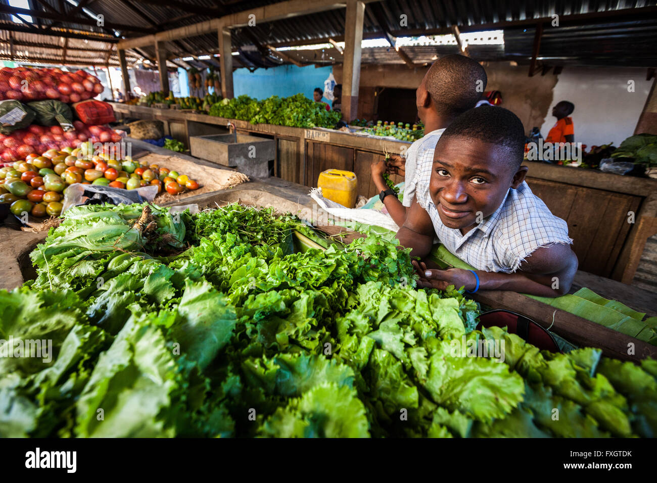 Mozambique, Africa, a man selling vegetables at the market in the city ...