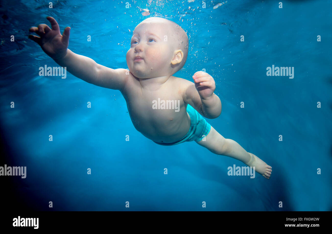 Young baby swims underwater in a swimming pool, Nirvana style Stock ...