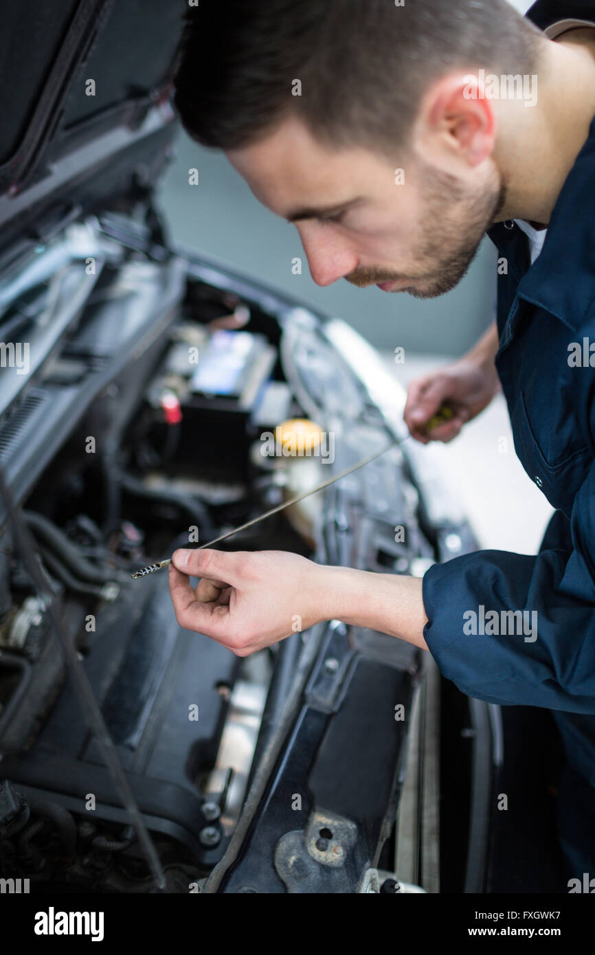 Mechanic checking the oil level in a car engine Stock Photo - Alamy