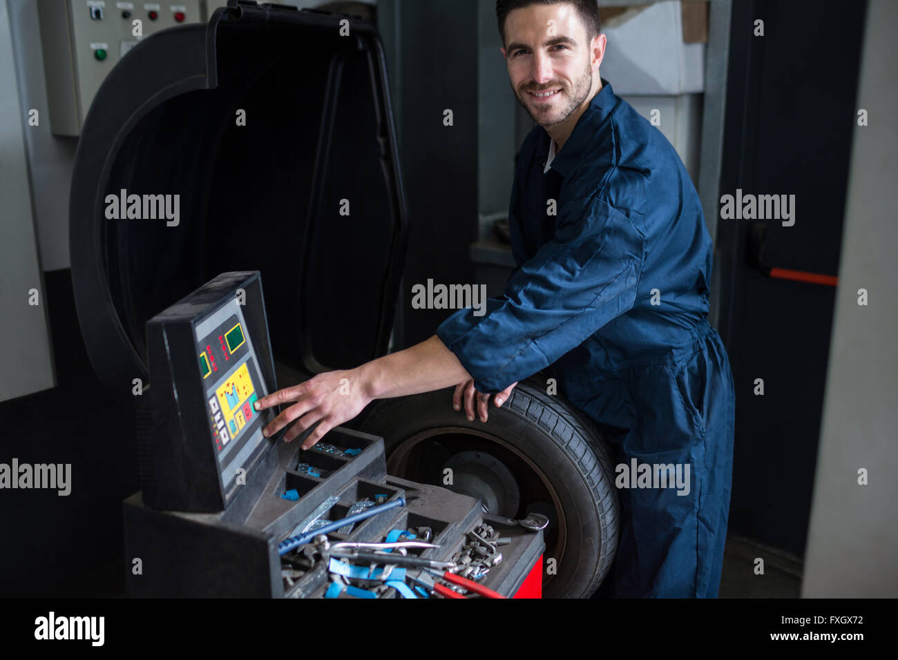 Mechanic prepares a tyre balance machine Stock Photo - Alamy