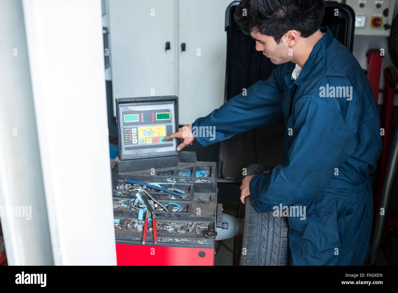 Mechanic prepares a tyre balance machine Stock Photo - Alamy