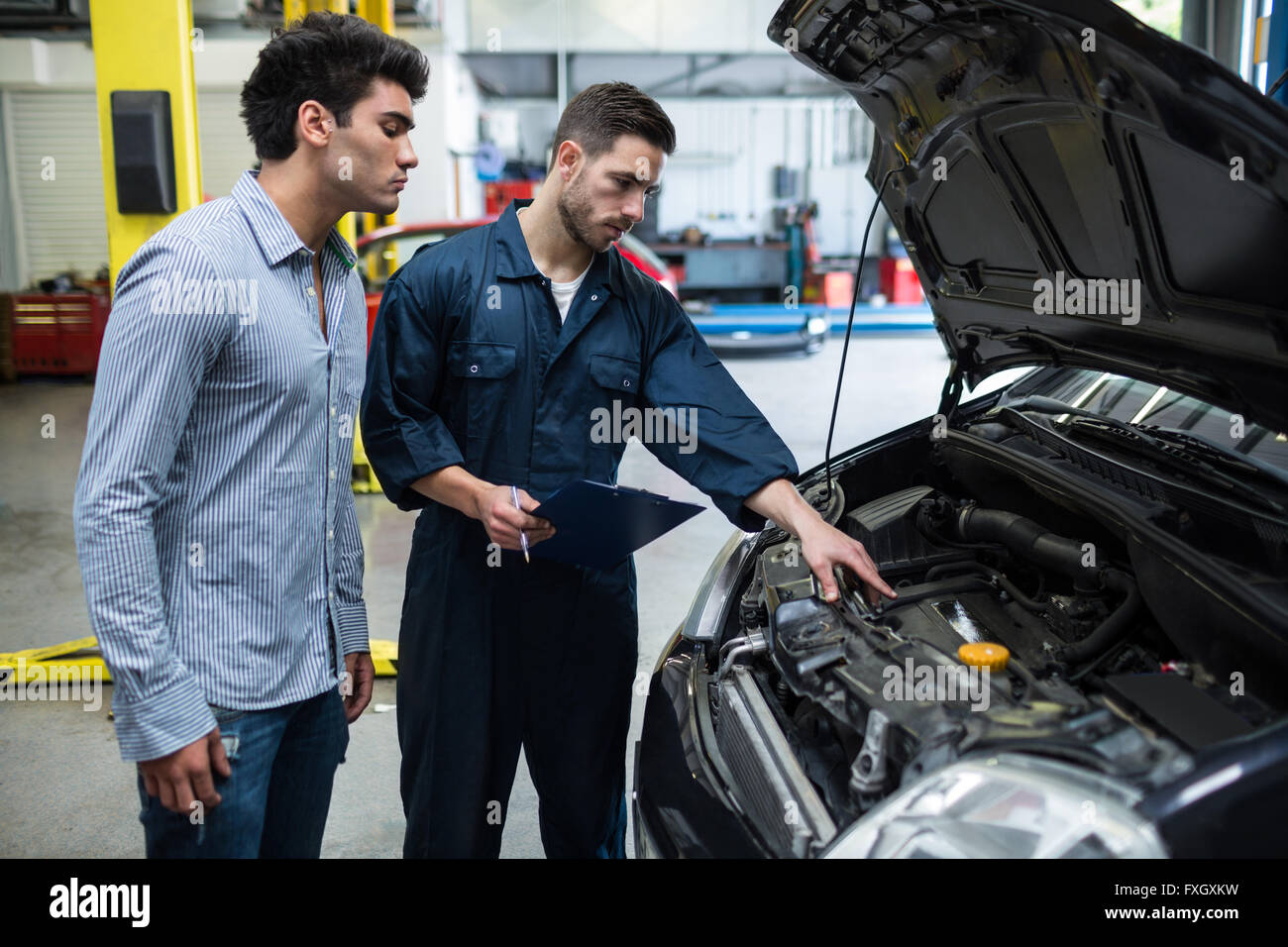 Mechanic showing customer the problem with car Stock Photo - Alamy