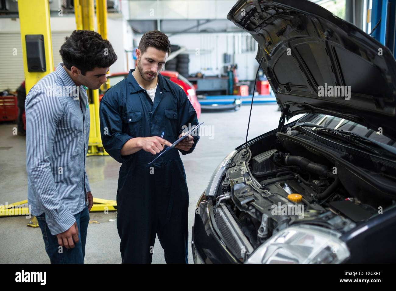 Mechanic showing the quotation to a customer Stock Photo - Alamy