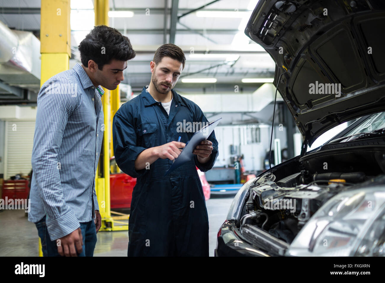 Mechanic showing the quotation to a customer Stock Photo - Alamy