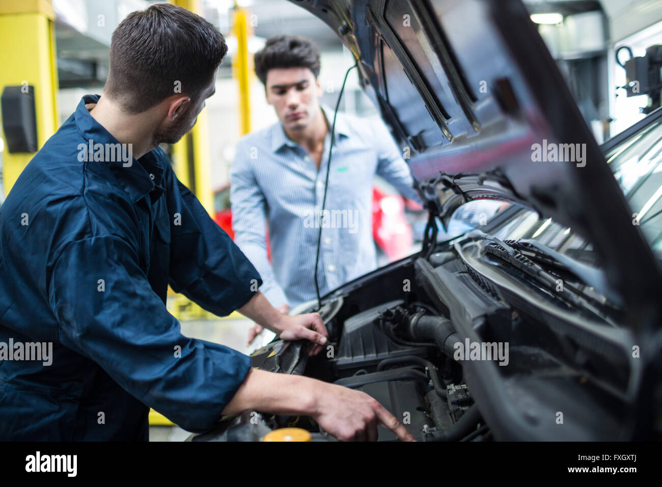 Mechanic showing customer the problem with car Stock Photo - Alamy