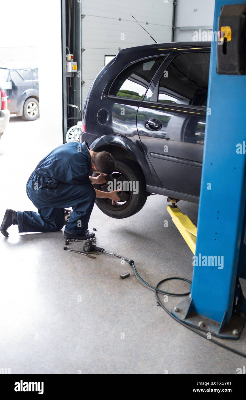 Mechanic changing car wheel with pneumatic wrench Stock Photo - Alamy