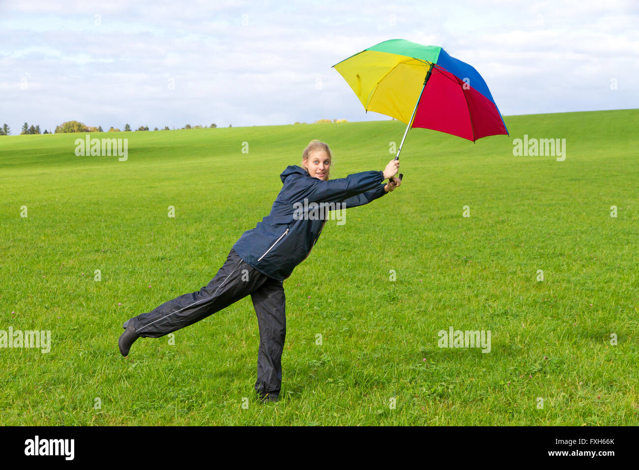 A young woman is fighting against the storm with her umbrella Stock ...