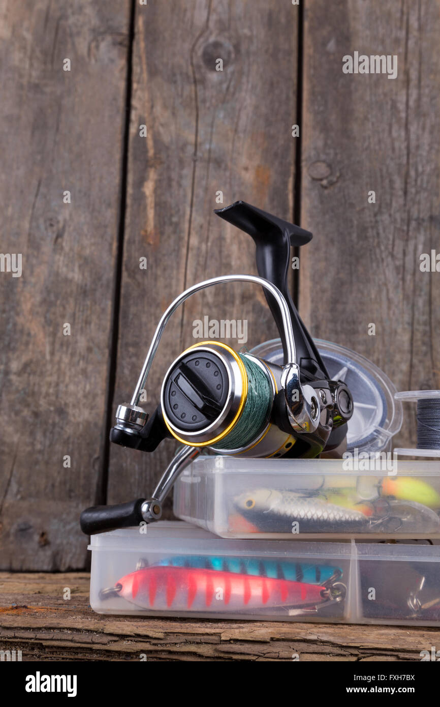 fishing tackles and fishing baits in box on vertical wooden board ...