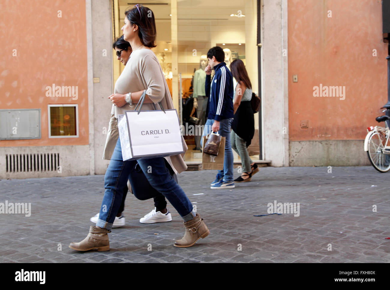 Pedestrian walks with his shopping bag in the center of Rome, Italy ...