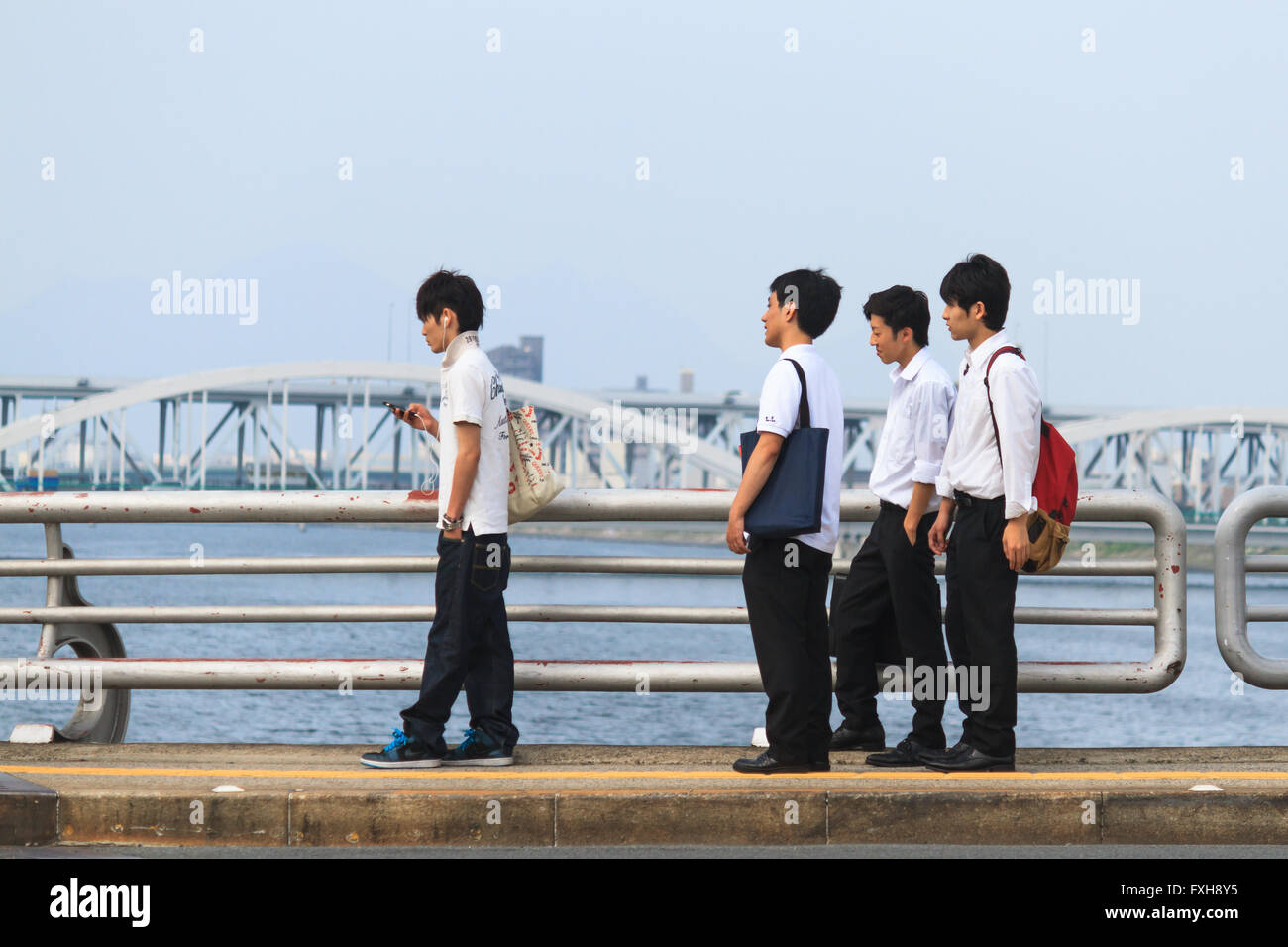 Japanese young men stand on a bridge above Aioi river in Hiroshima ...