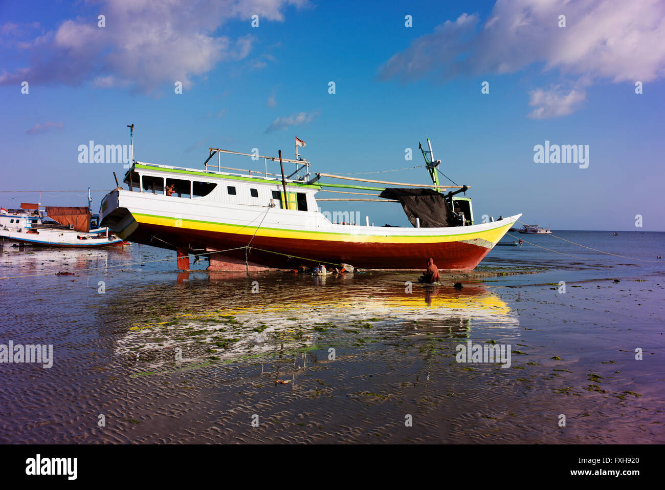 Traditional pinisi schooner has maintenance carried out while it lies ...