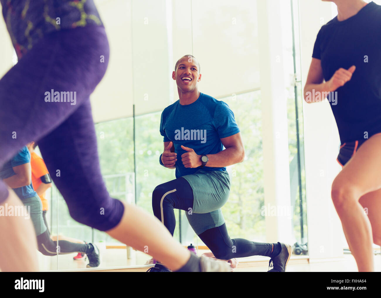 Smiling man lunging in exercise class Stock Photo - Alamy