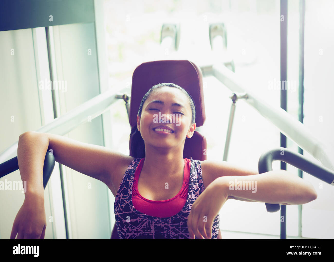 Tired woman resting at exercise equipment in gym Stock Photo - Alamy