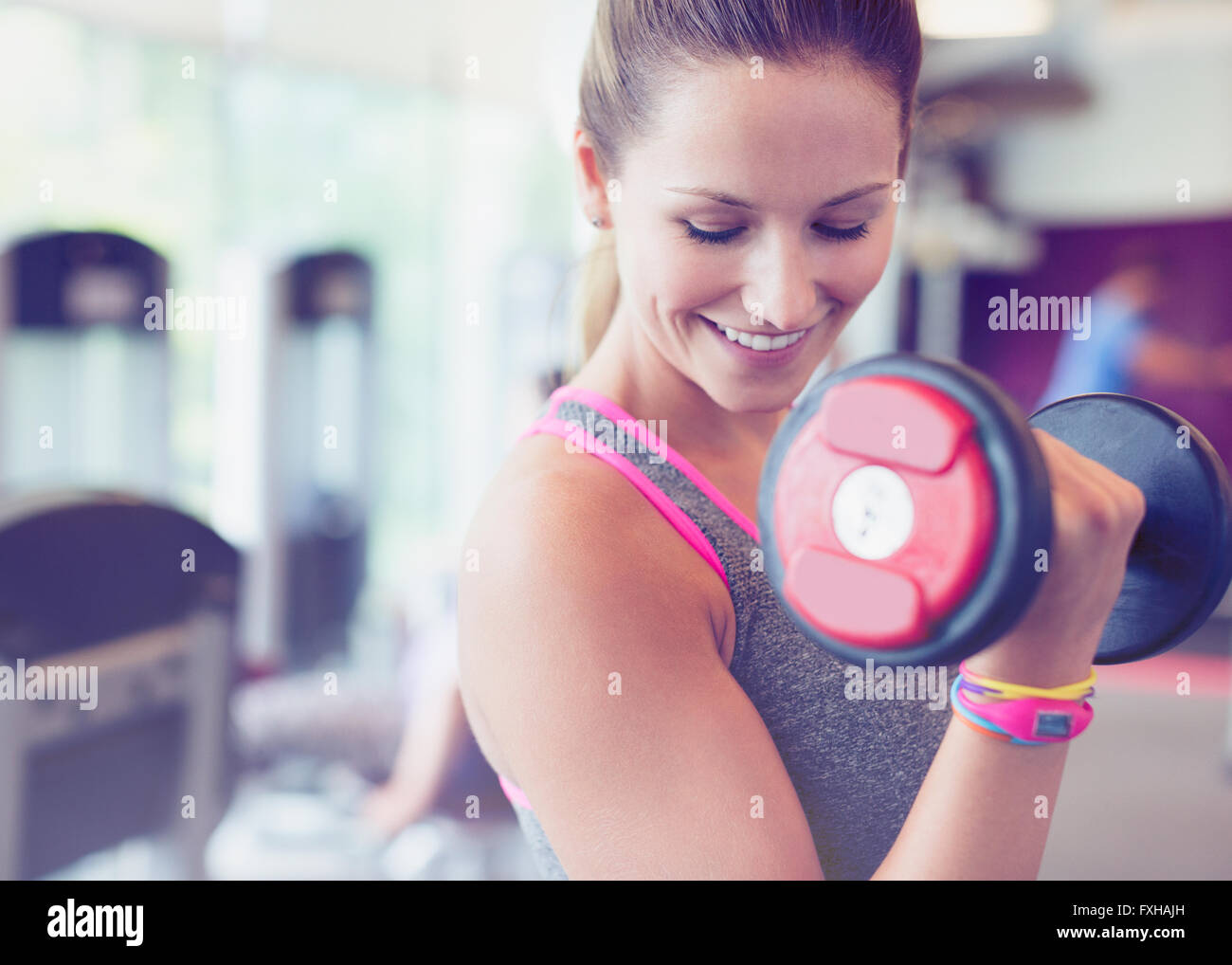 Close up smiling woman doing dumbbell biceps curls at gym Stock Photo ...
