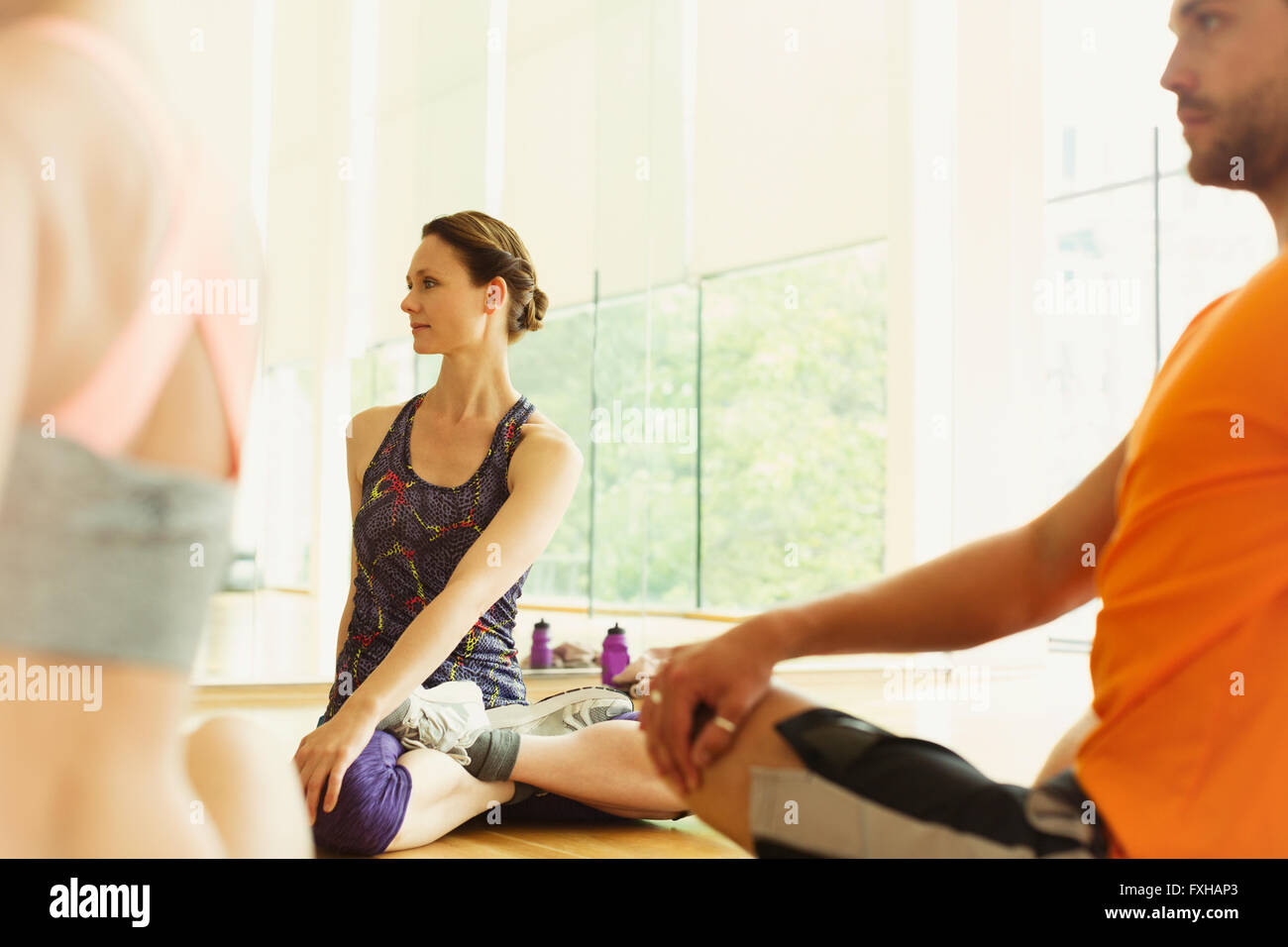 Fitness instructor leading class in twisting stretch Stock Photo - Alamy