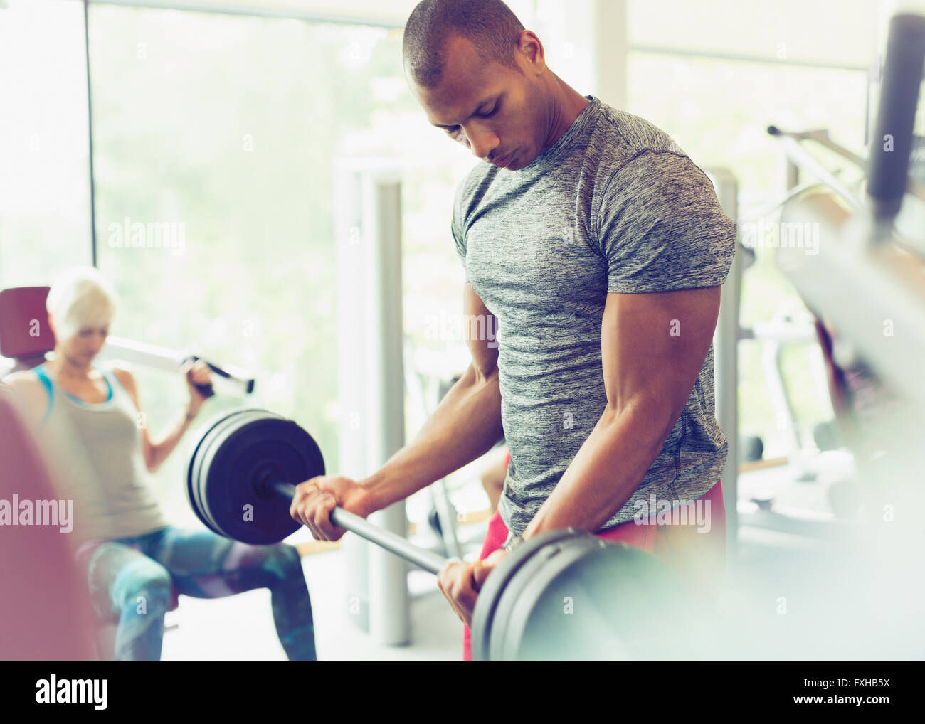 Focused man doing barbell biceps curls at gym Stock Photo - Alamy