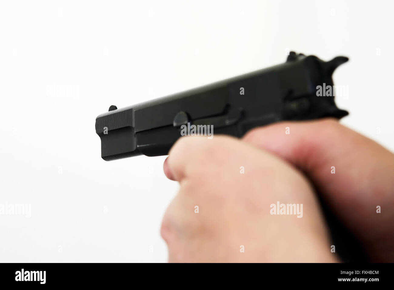 Hands of a man pointing a pistol on light background Stock Photo - Alamy