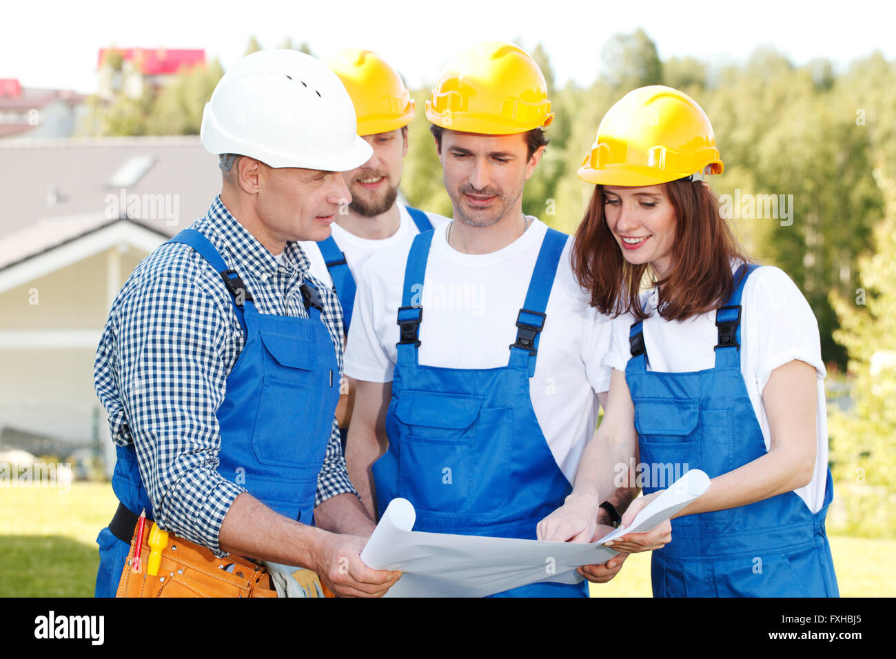 Team of builders with construction plan outdoors Stock Photo - Alamy