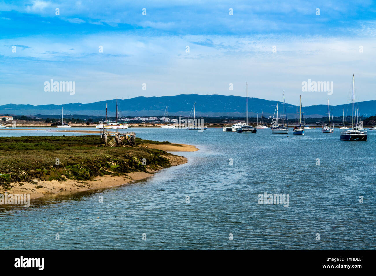 River estuary with small boats and yachts anchored off shore, Blue ...
