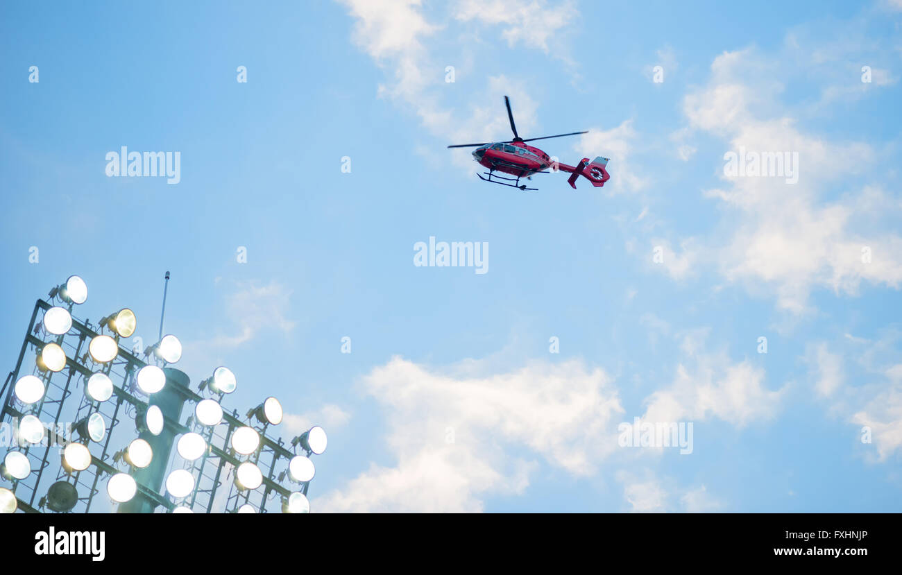 flying helicopter over football spotlights turned at sunset Stock Photo ...
