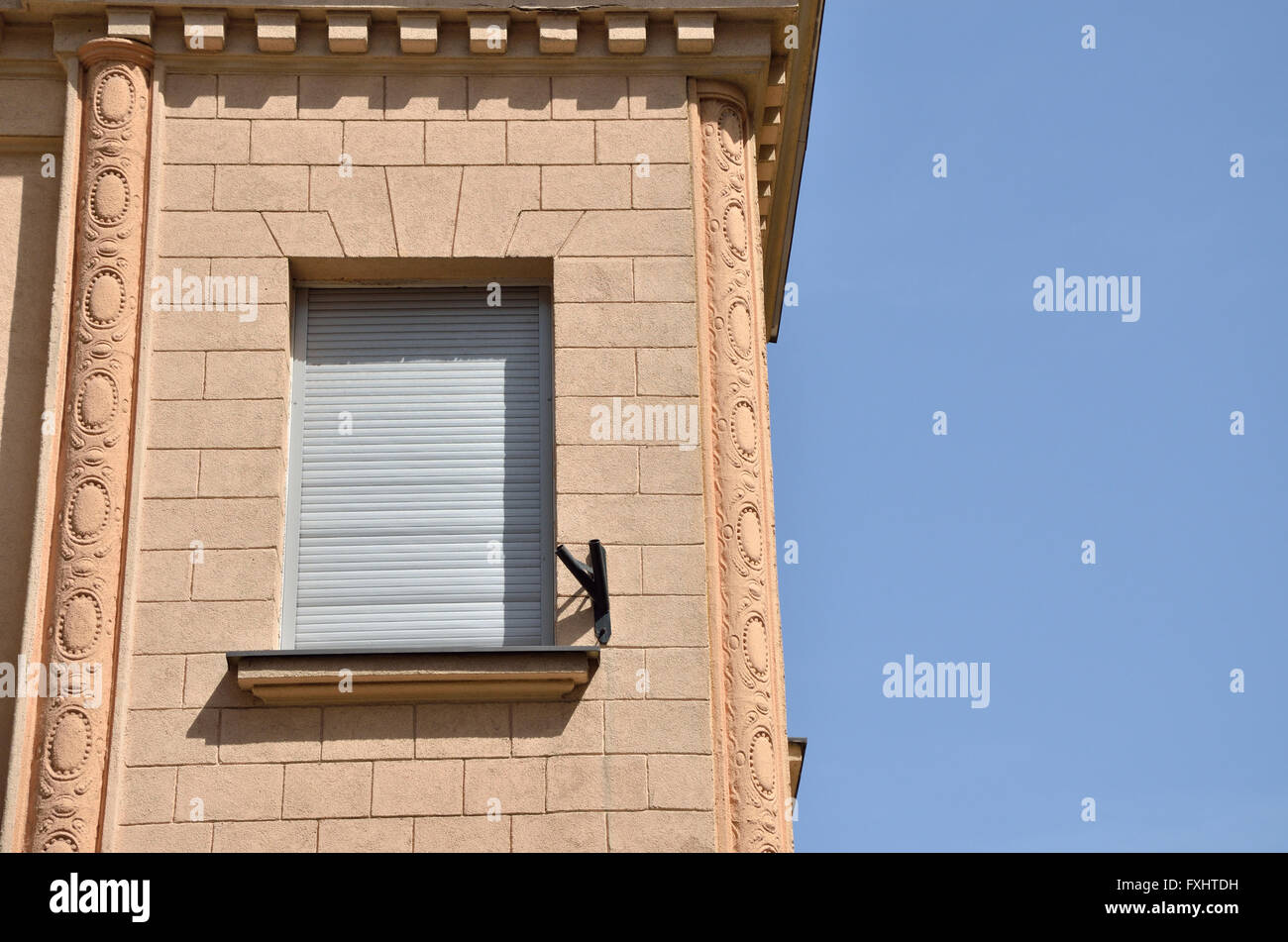 Window covered with sunblind on a renovated building facade and blue ...