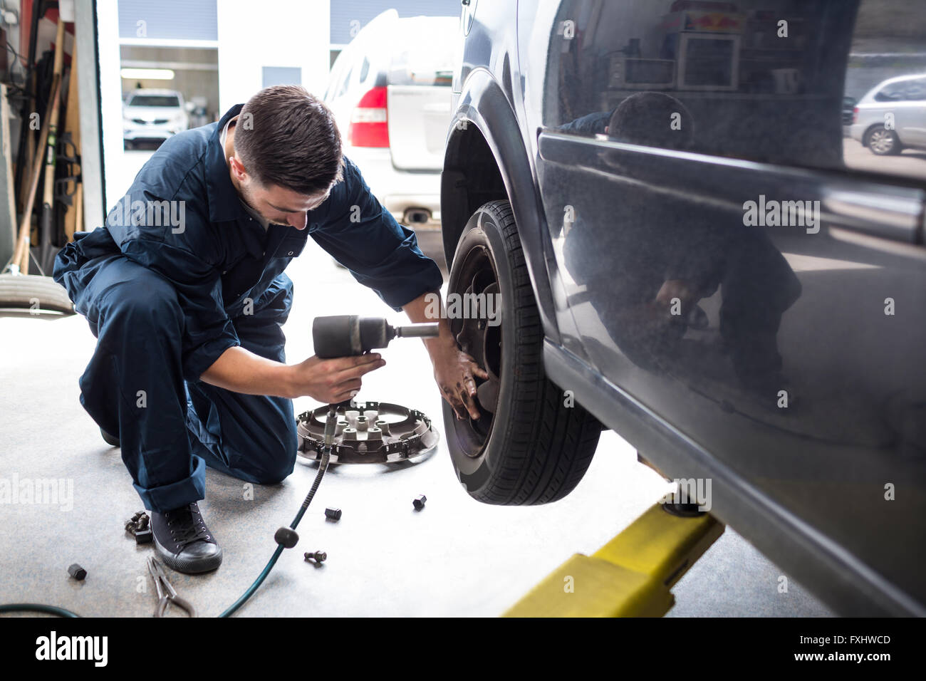 Mechanic changing wheel car hi-res stock photography and images - Alamy